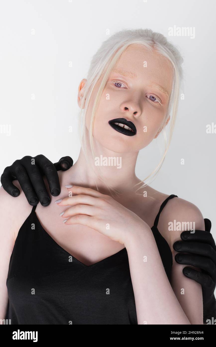 Male hands in black paint hugging albino model isolated on white Stock ...