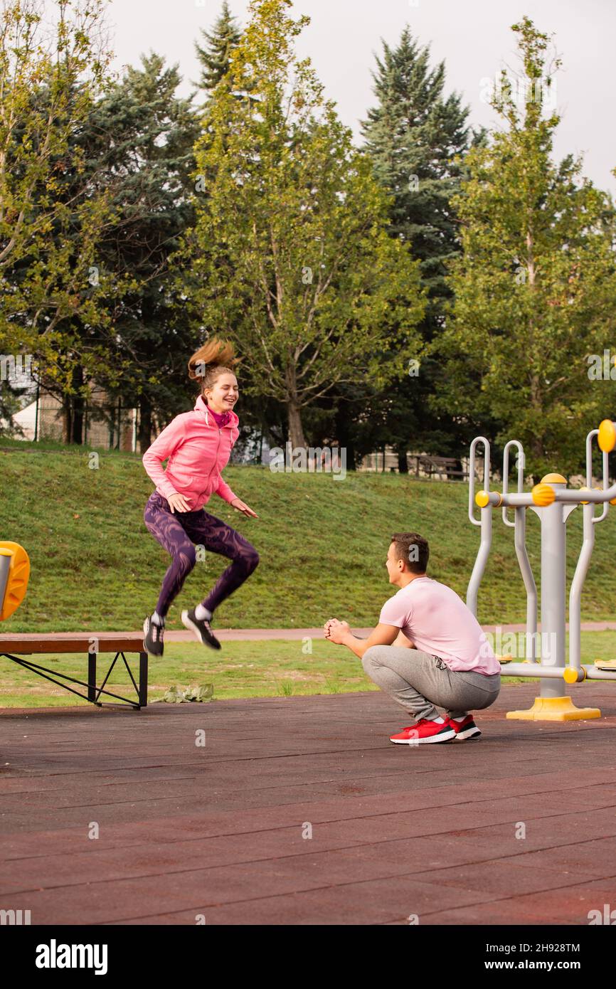 Amazing and beautiufl couple is doing some jumping exercise together in ...