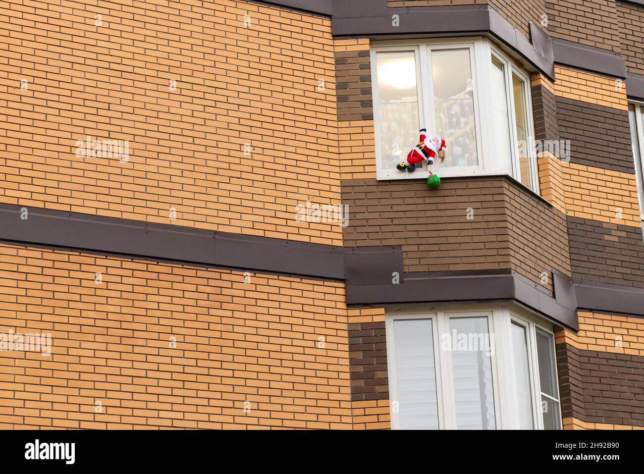 Santa Claus Frost climbs through the window. A small toy Santa with a ...