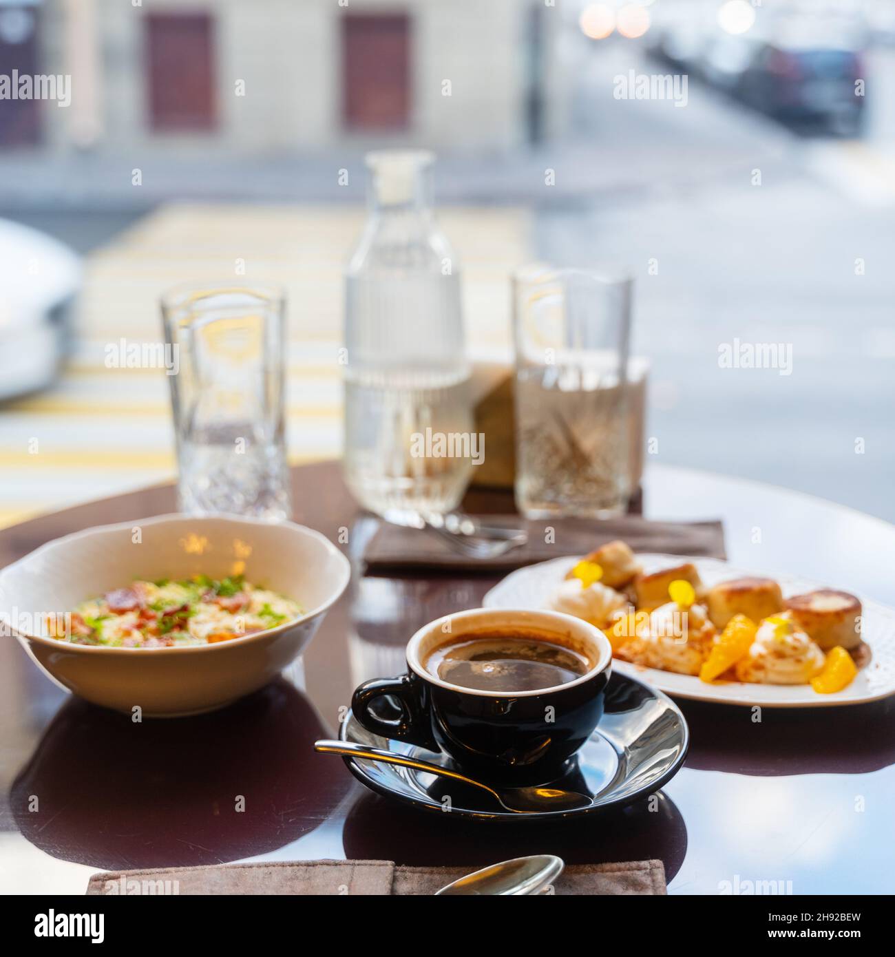 Gourmet breakfast at cafe. Porridge, cheesecakes and coffee. Table at ...