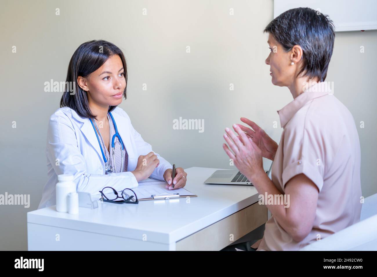 Doctor carefully listening to patient complaints about symptoms at ...