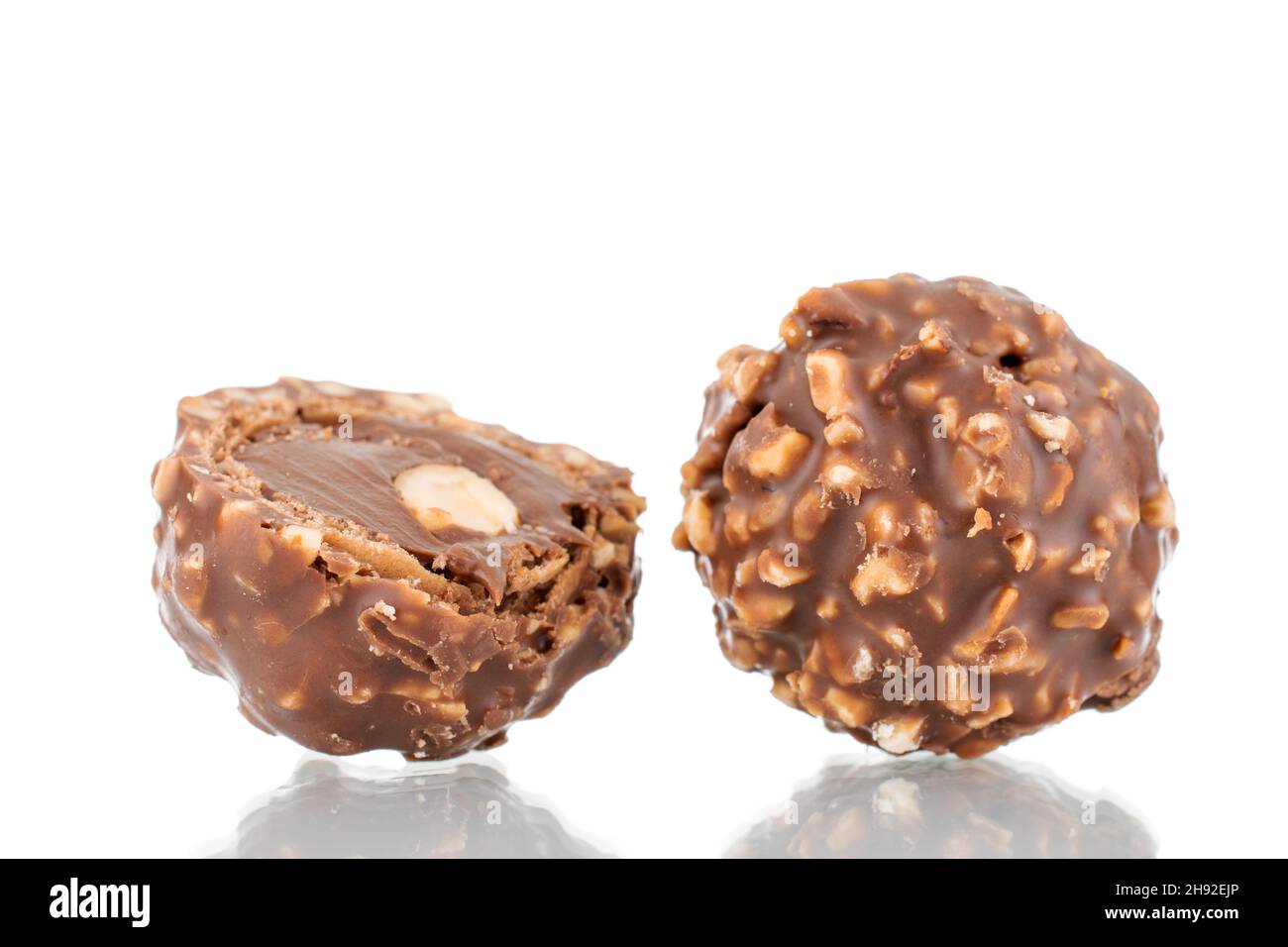 One whole and half of chocolate candy with nuts, close-up, isolated on ...
