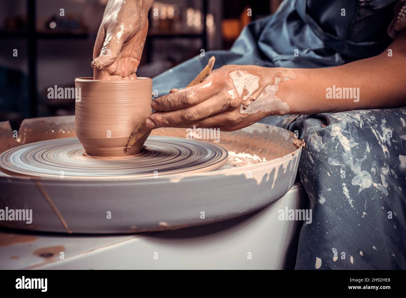 Close-up A woman potter in beautifully sculpts a deep bowl of brown ...