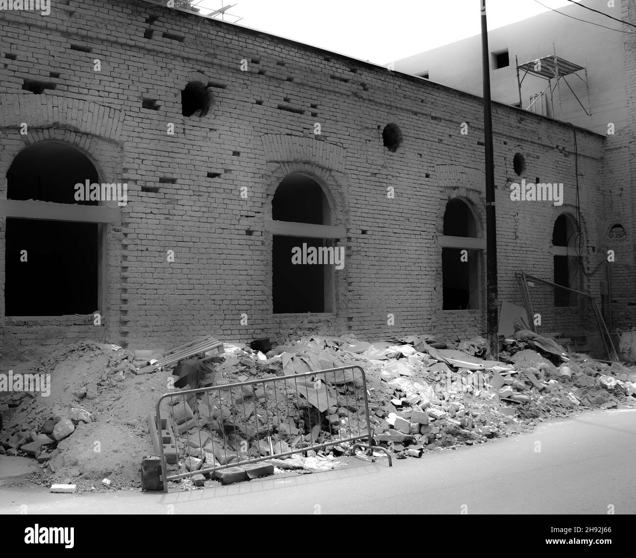 Grayscale shot of an old abandoned place with arch window openings ...