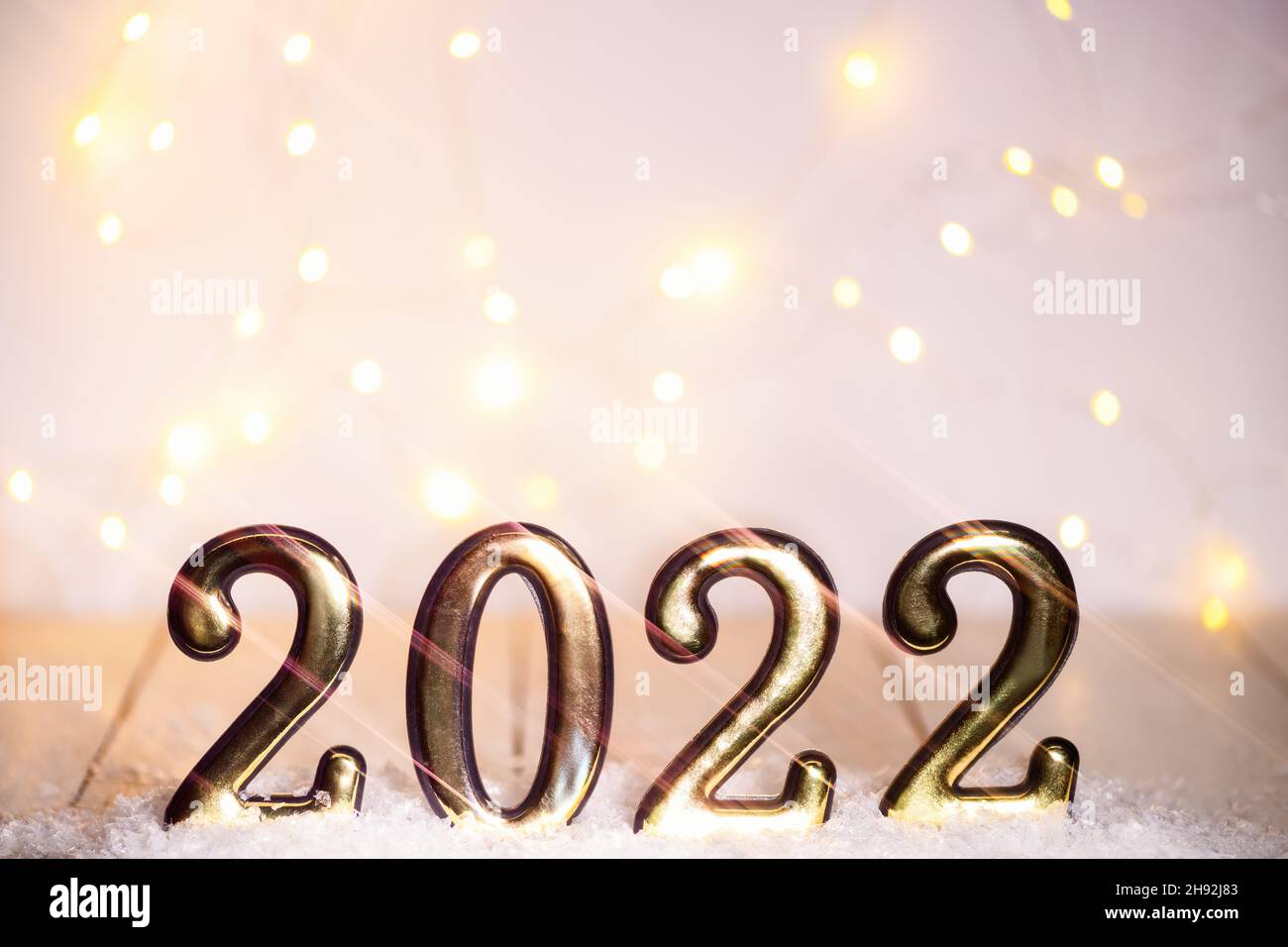 Gold numbers 2022 with snow with anamorphic filter and luminous garland ...
