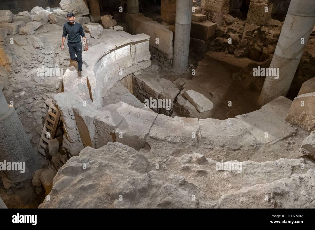 A laborer walks over an ancient Roman theater-like structure from the ...
