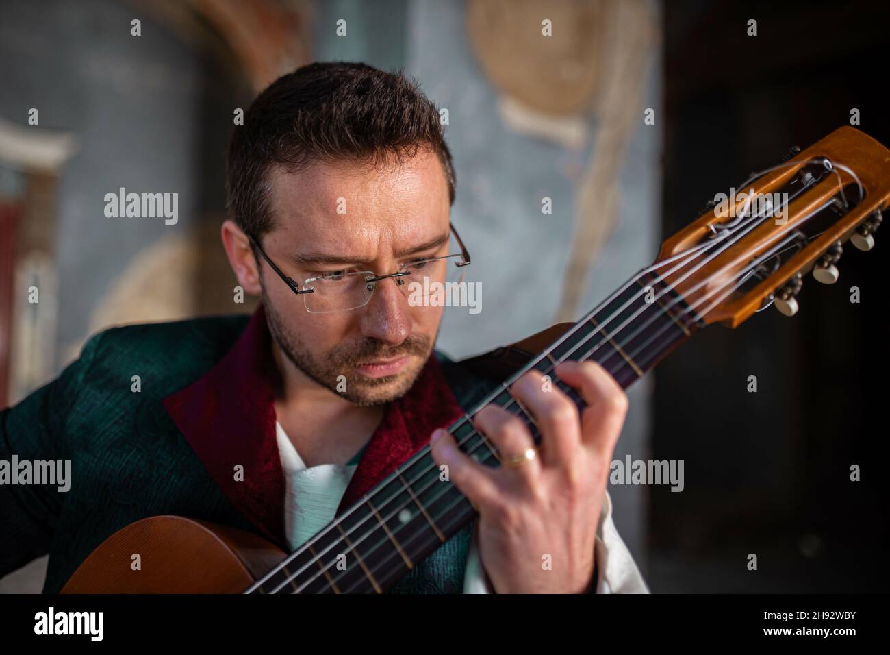 Serbian man in glasses playing the guitar Stock Photo - Alamy