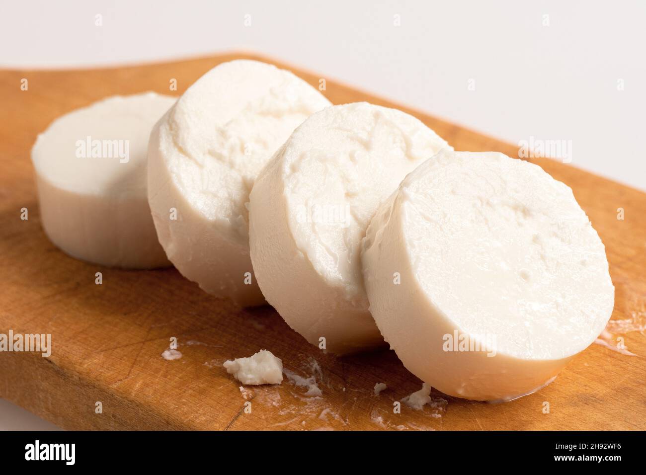 Rounds of goat cheese on wood chopping board Stock Photo - Alamy