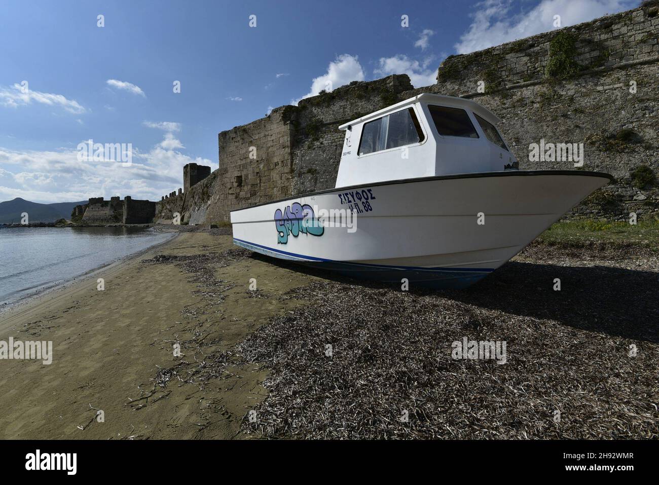 Traditional Greek fishing boat with scenic view of the medieval Castle ...