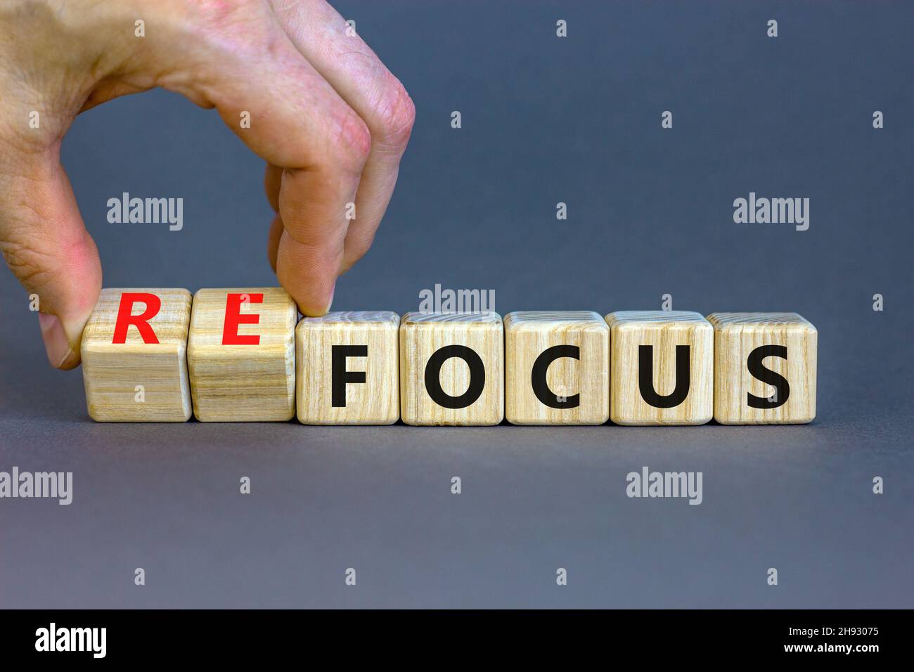 Focus or refocus symbol. Businessman turns wooden cubes and changes the ...