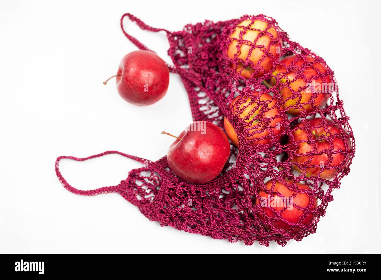 fruits apples red in a knitted string bag on an isolated white ...