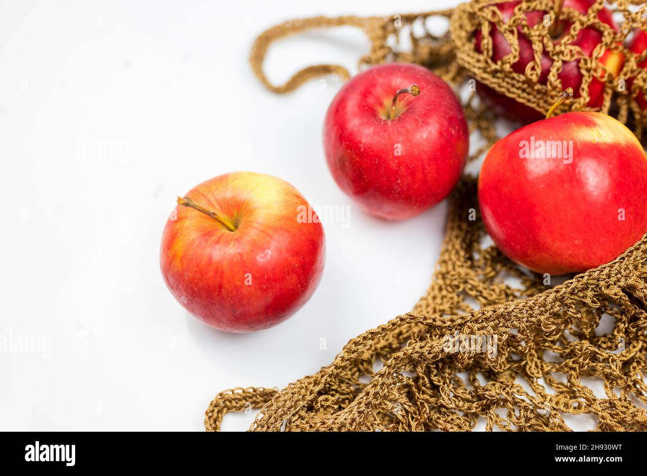 fruits apples red in a knitted string bag on an isolated white ...