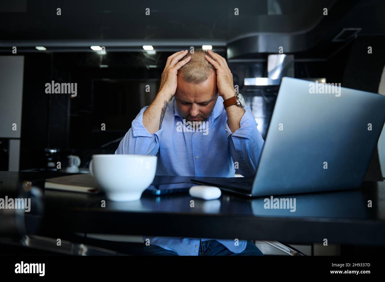 Frustrated businessman looking at the laptop monitor screen holding his ...