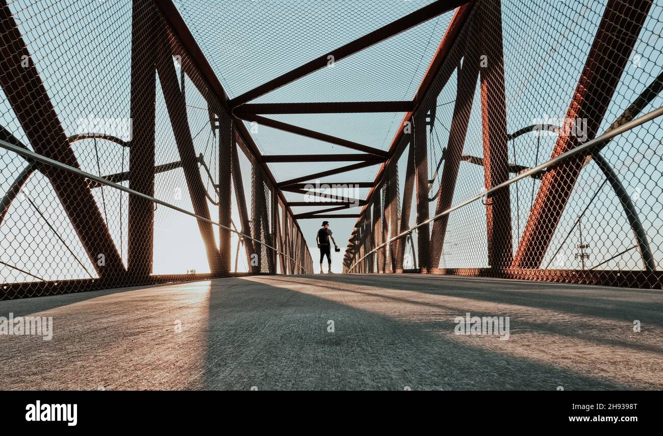 Young man walking on a pedestrian bridge Stock Photo - Alamy