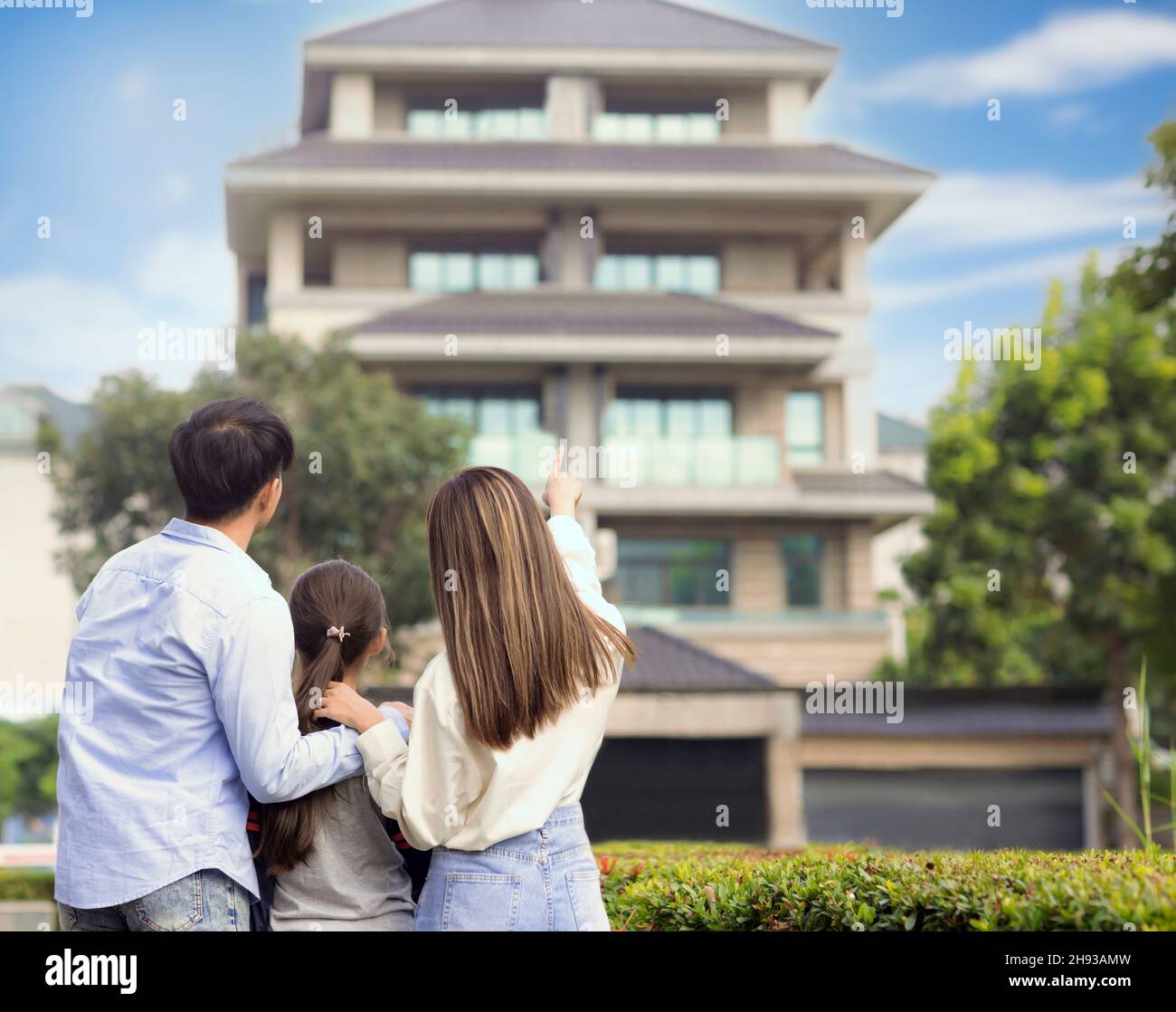 Rear view of family stand outside before their new house Stock Photo ...