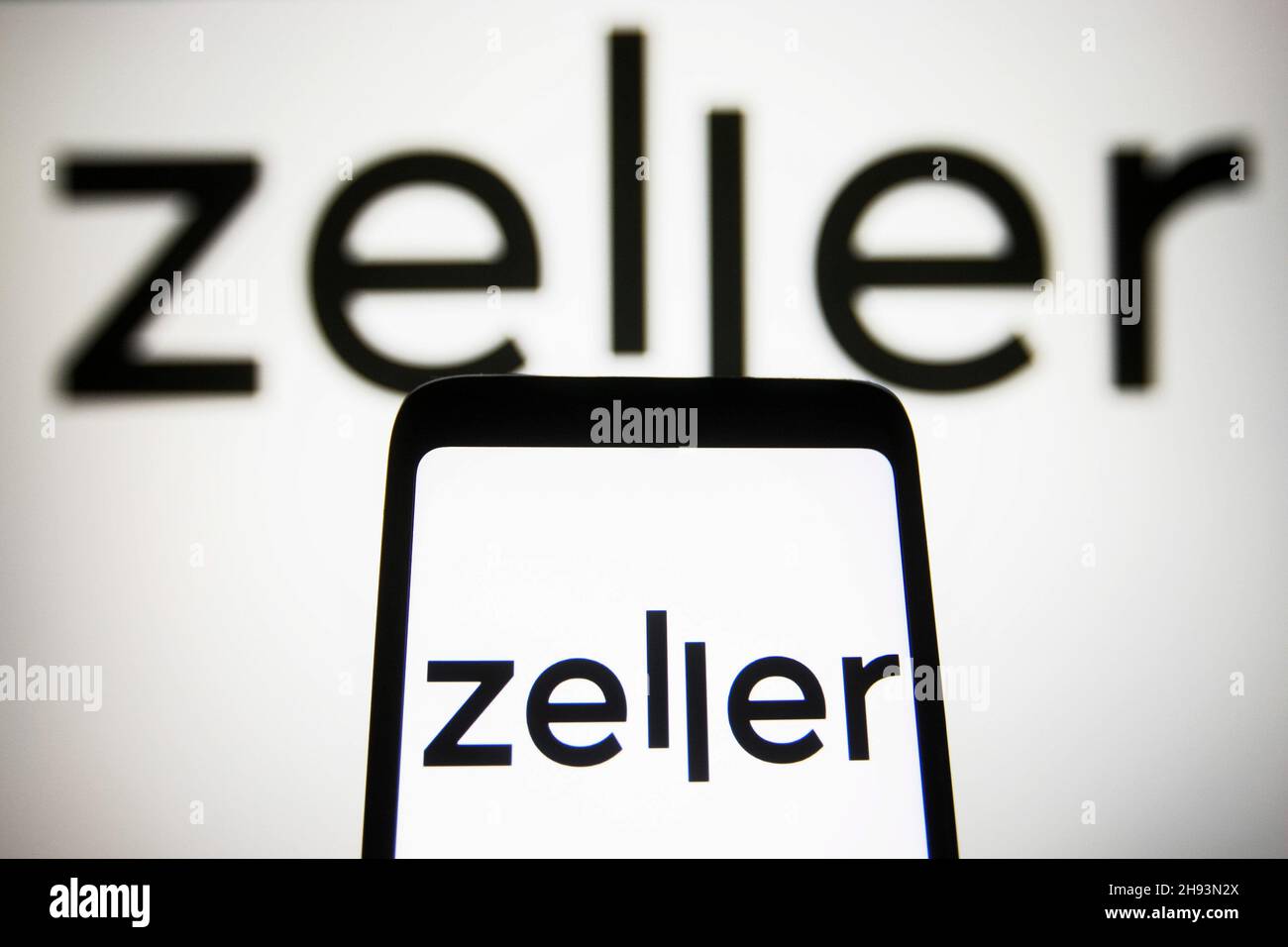 In this photo illustration, Zeller logo is seen displayed on a smartphone and a computer screen ...