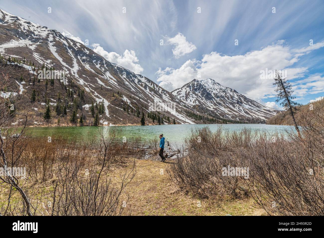Hiker standing lakeshore on a isolated lake in northern Canada during ...