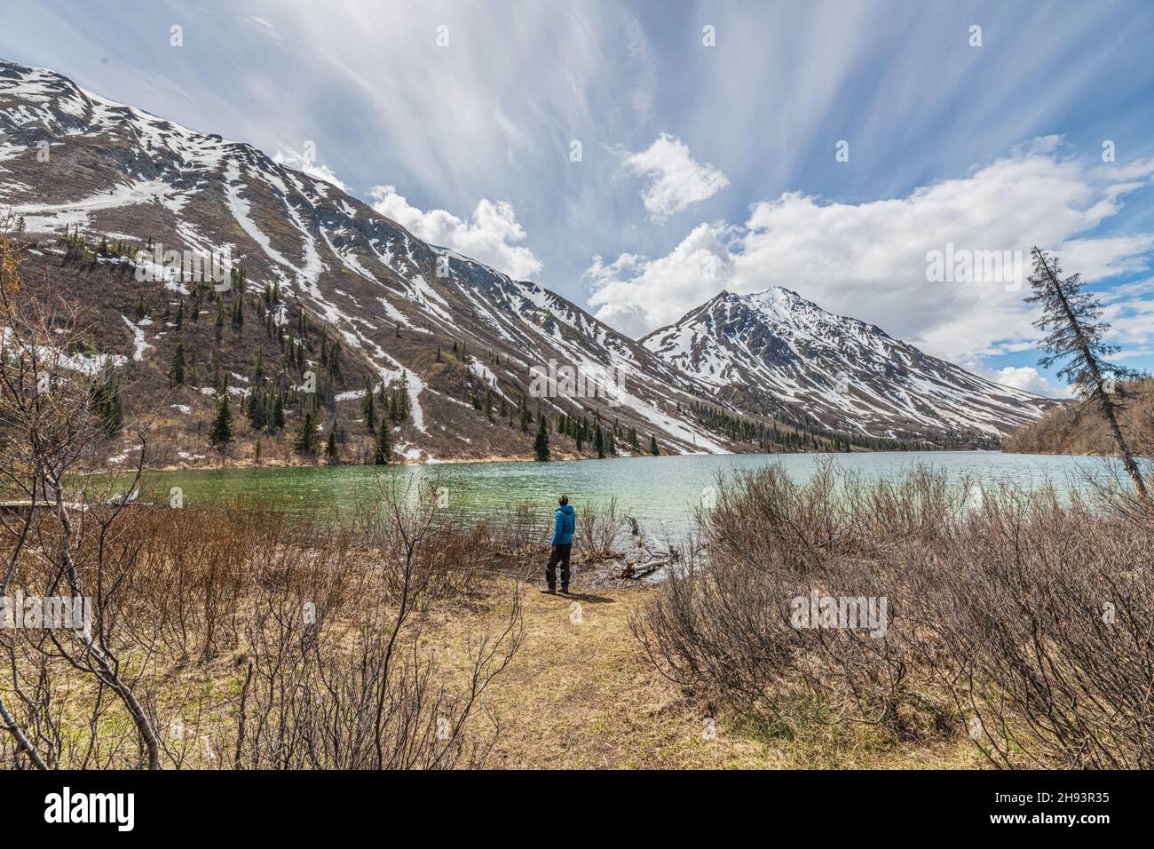 Hiker standing lakeshore on a isolated lake in northern Canada during ...