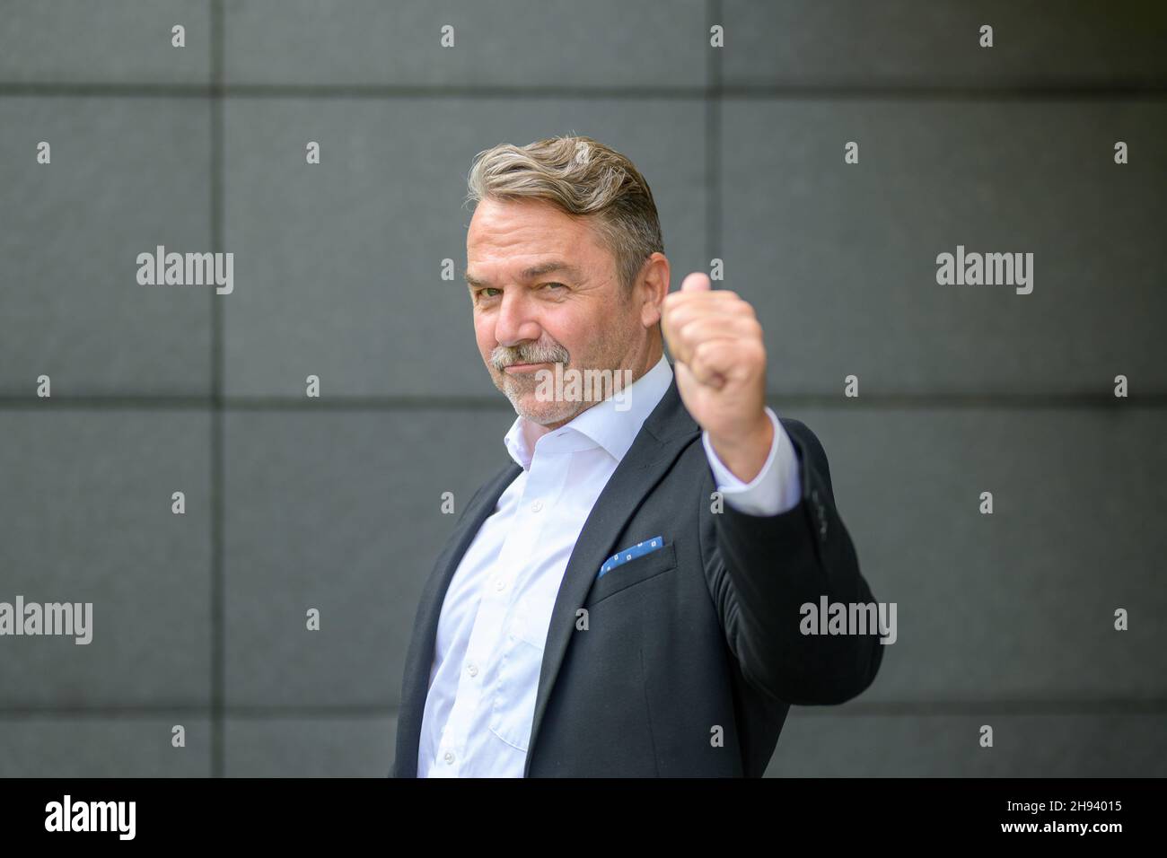 Triumphant stylish businessman giving a thumbs up gesture with a smile ...