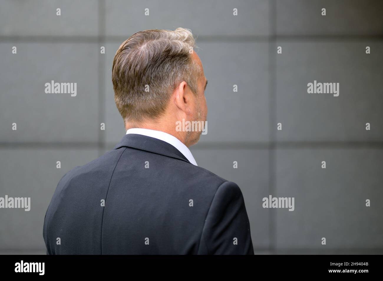 Back view portrait of a confident handsome middle-aged man wearing ...