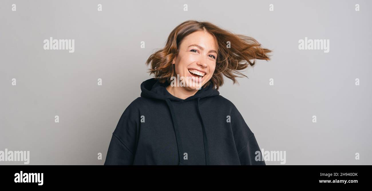 Portrait of charming laughing young woman over grey background Stock ...