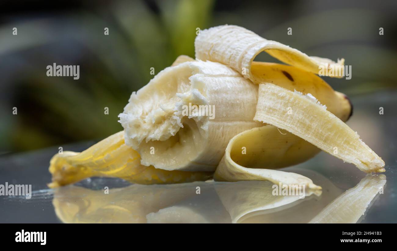 Half-eaten banana with shadow on the glass, Open Banana isolated on a ...