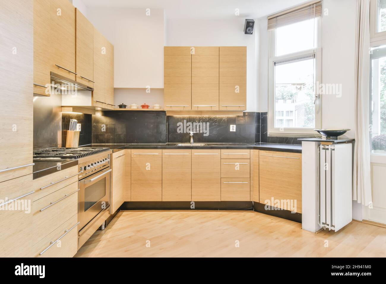Interior of contemporary open plan kitchen with built in appliances and ...