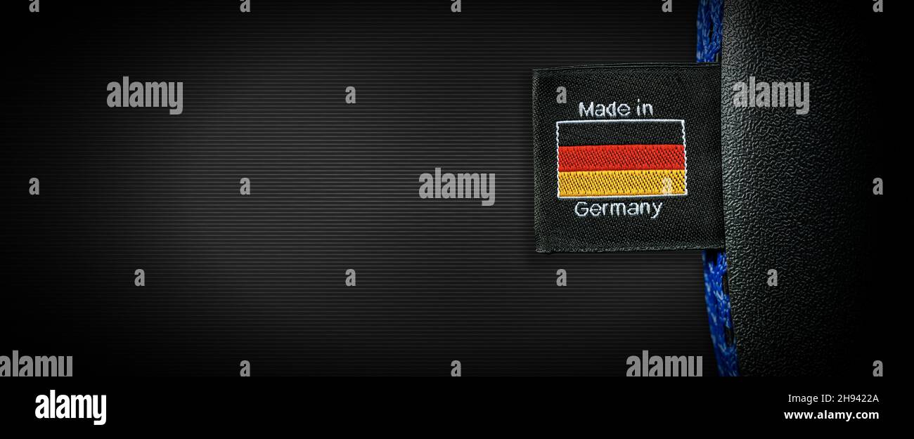 Label with German Flag and text Made in Germany sewn on a black fabric ...