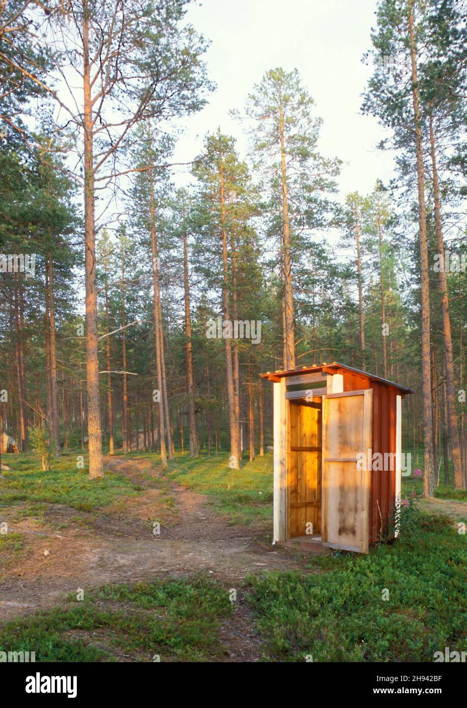 Simple wooden loo far out in rural area in 2005, analog. Trees and ...