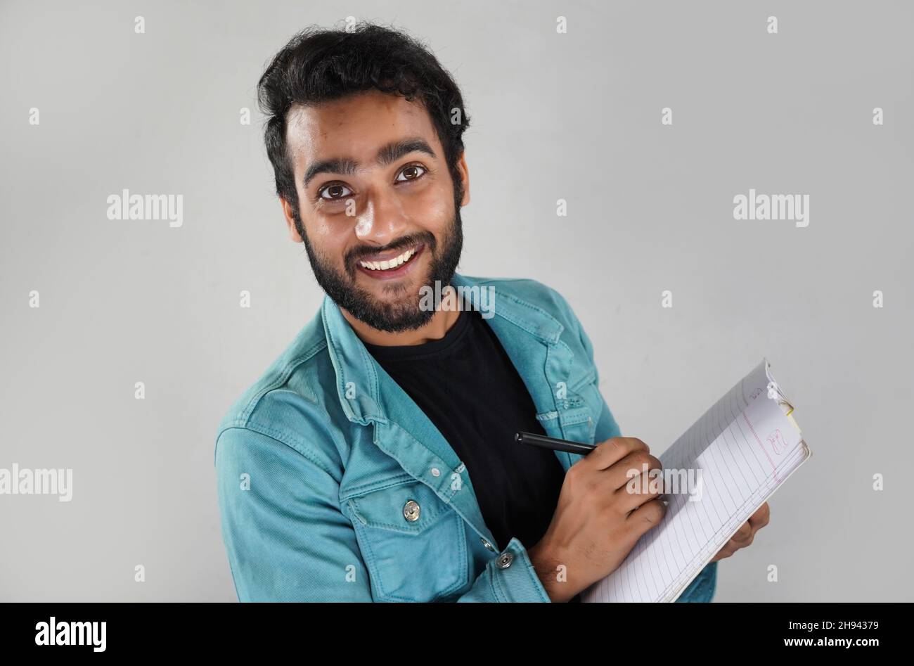 a man with note book writing something Stock Photo - Alamy