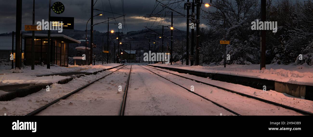 Railtracks and train station in the snow at dusk Stock Photo - Alamy
