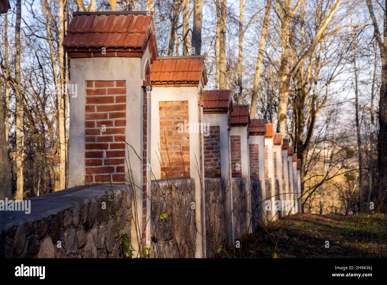 Fence around the park build from bricks and stones, part of residential ...