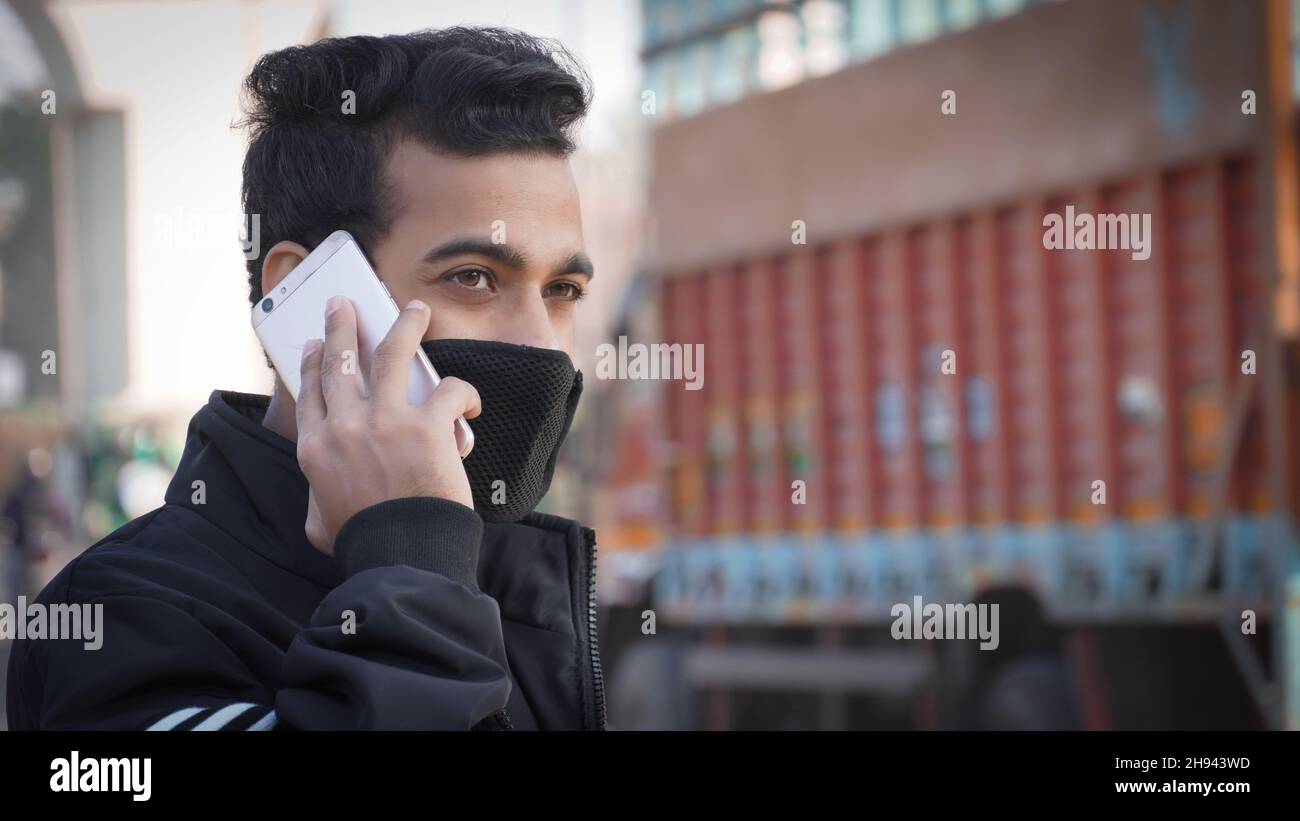 Young man holding mobile phone, using smartphone, making a call ...