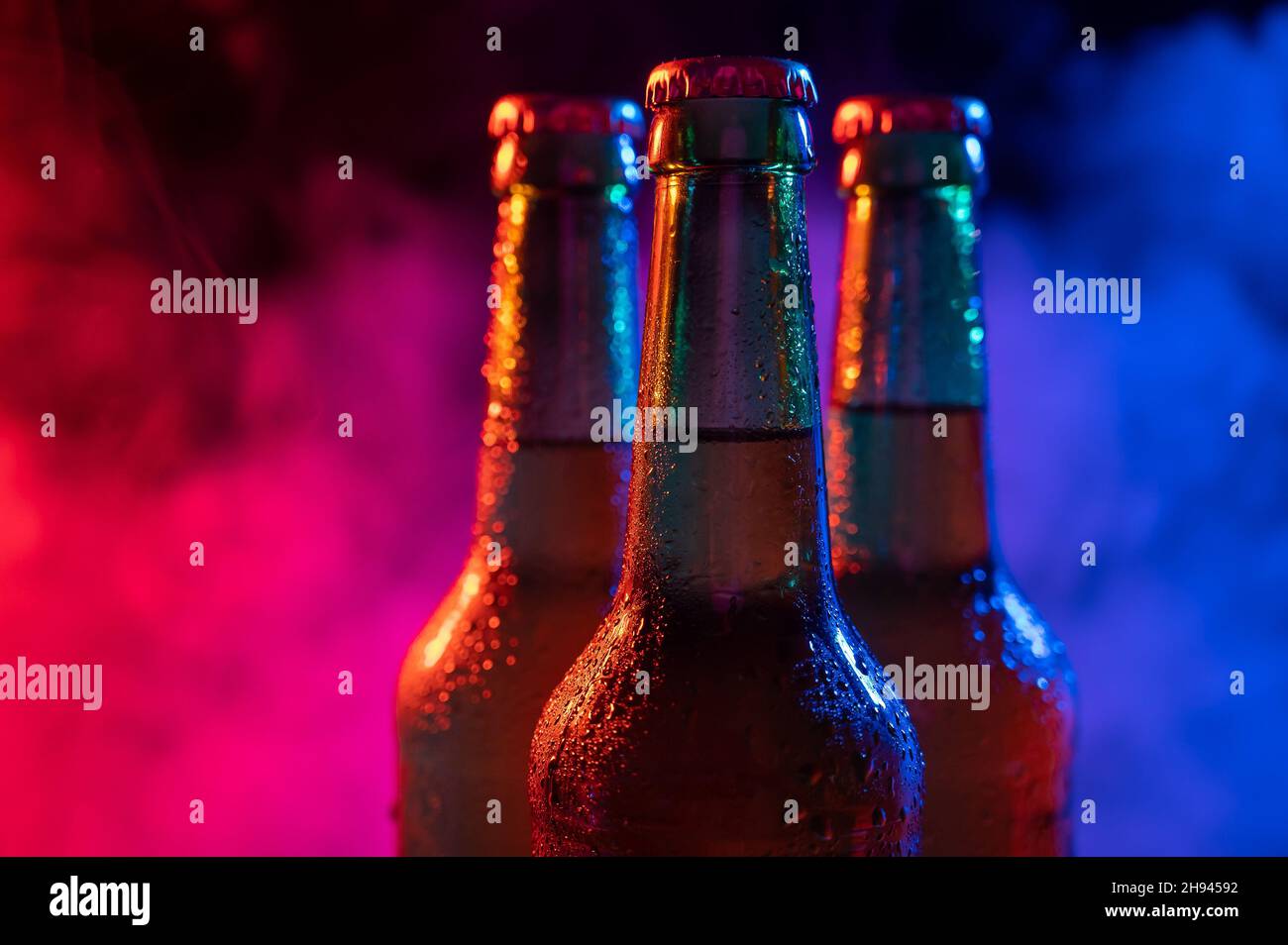 Three bottles of beer in a blue-pink mist Stock Photo - Alamy