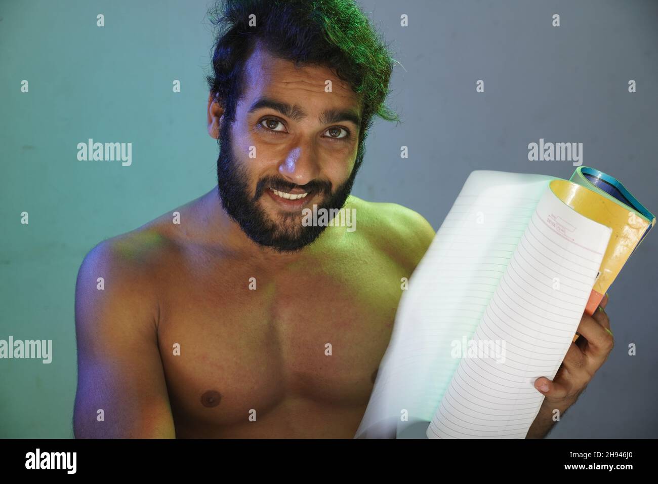 young actor is going to write smiling face without cloths studio shot ...