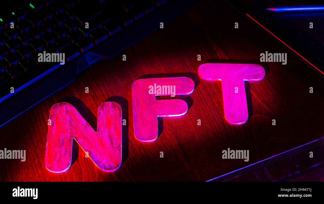 NFT ( Non-Fungible Token ) text of letters illuminated with neon light ...