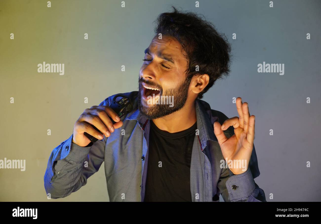 man try to sing high note using his mic Stock Photo - Alamy