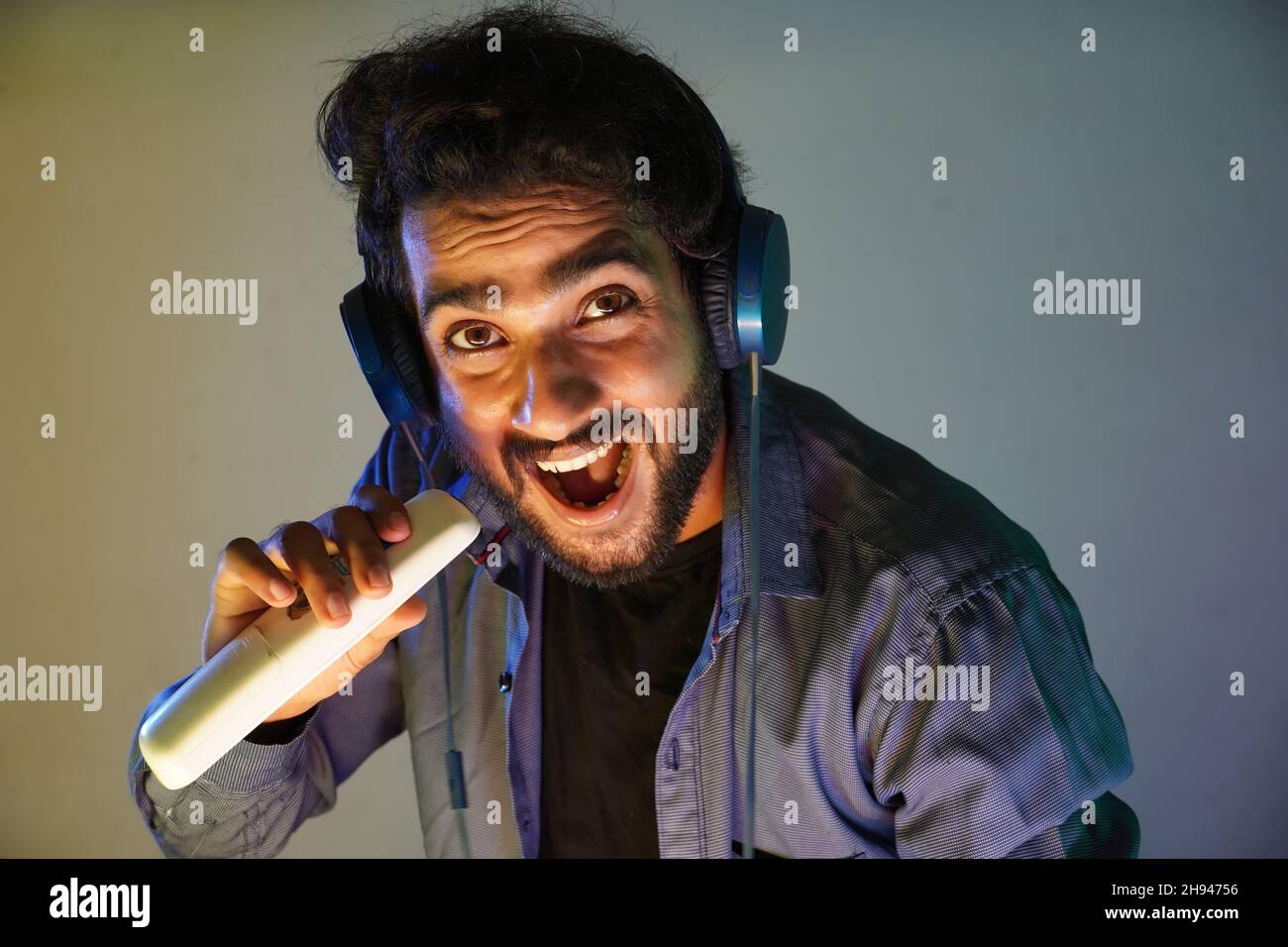 man try to immatate singing high note using his ac remote Stock Photo ...