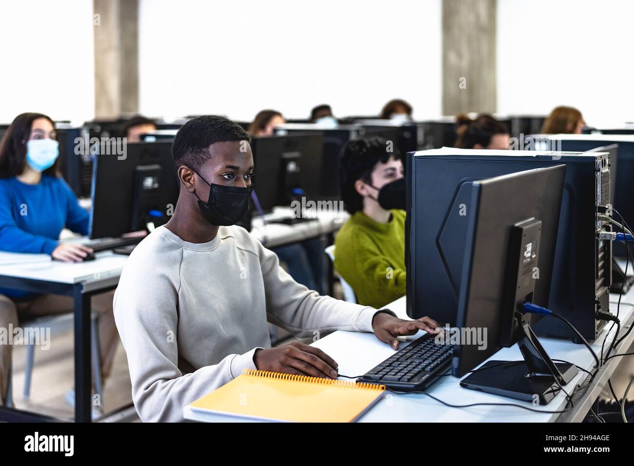 Young multiracial students taking an exam in high school while wearing ...