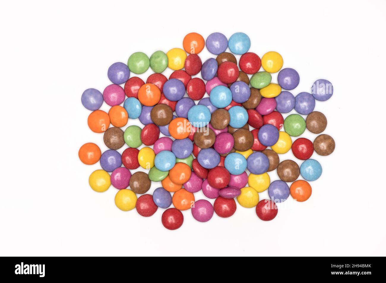 colorful round sweets in different colors on a pile isolated on white ...