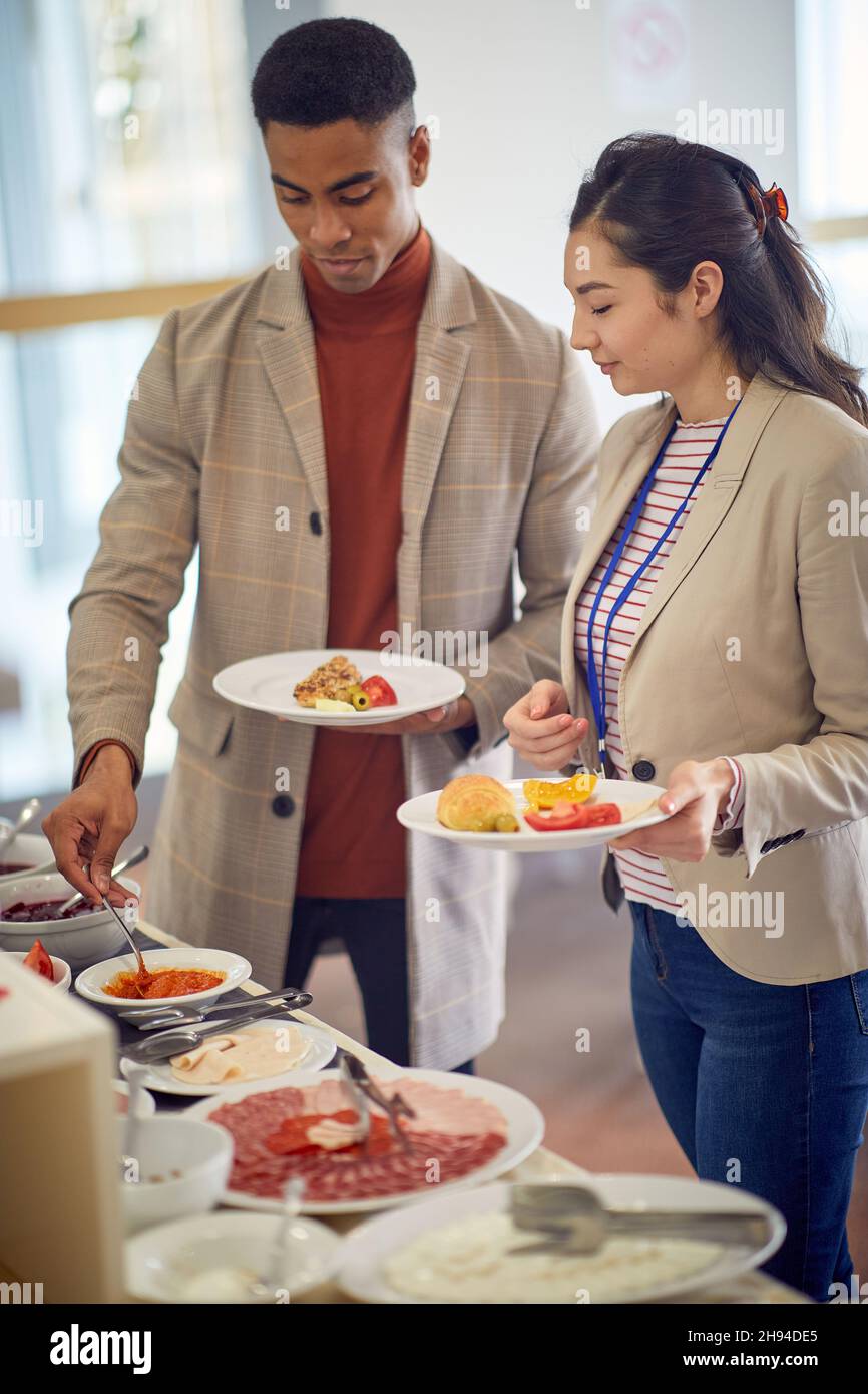 Smiling Multiethnic Colleagues Having Lunch At Office Cafeteria Stock