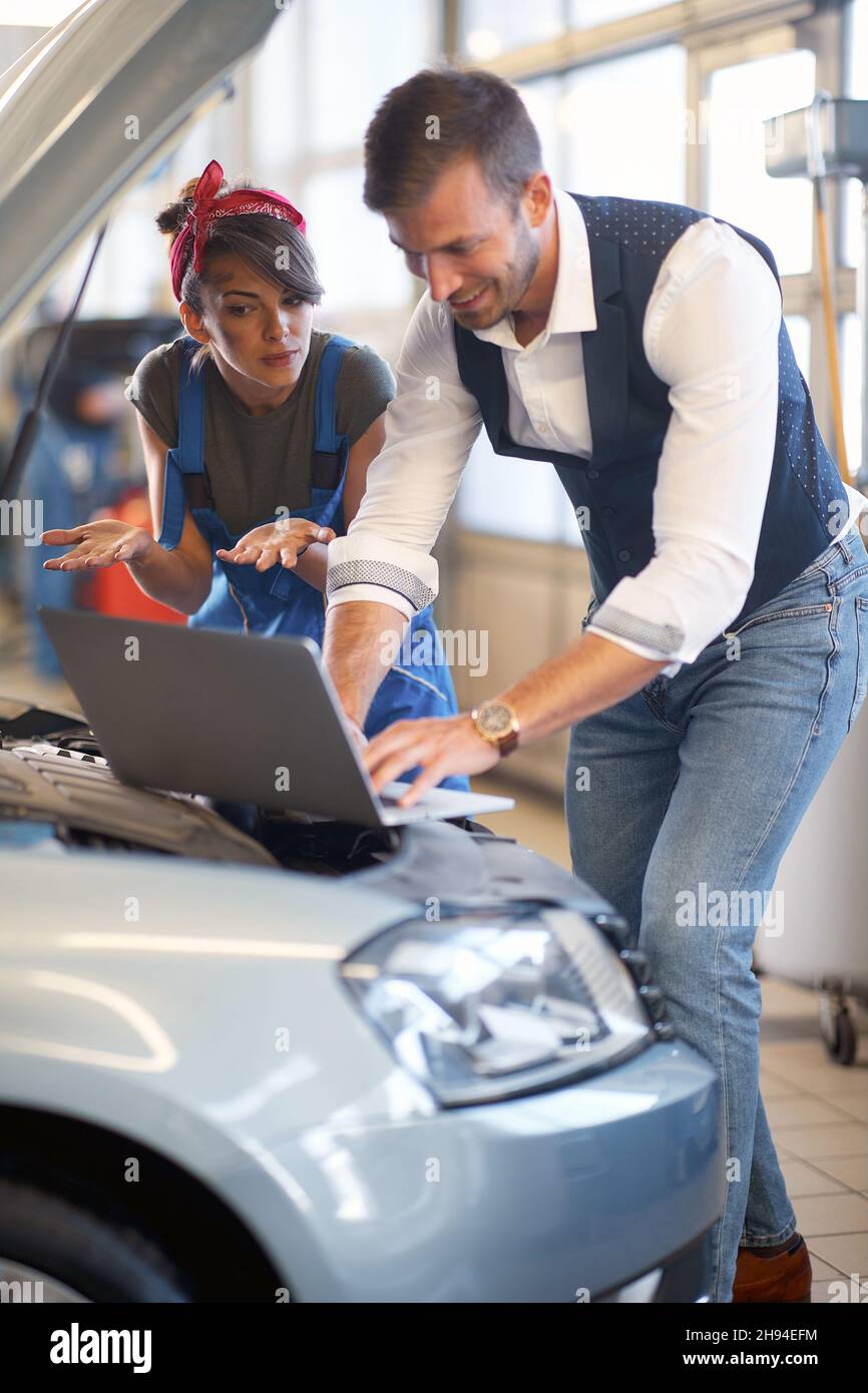 Girl mechanic learning in the car workshop with colleague Stock Photo ...