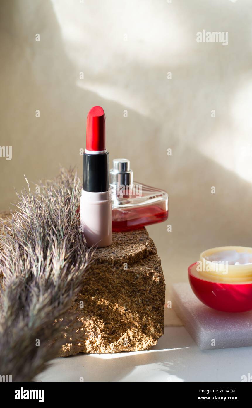 Red lipstick and perfume on a natural stone catwalk Stock Photo - Alamy
