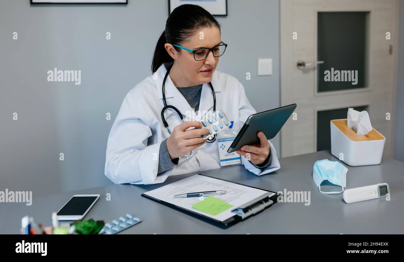 Female doctor reading drug leaflet on tablet Stock Photo - Alamy