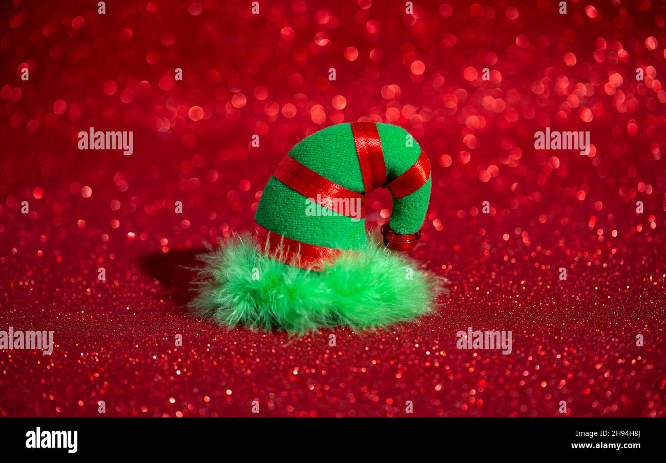 Elf cap on a red shiny background. Card Stock Photo - Alamy