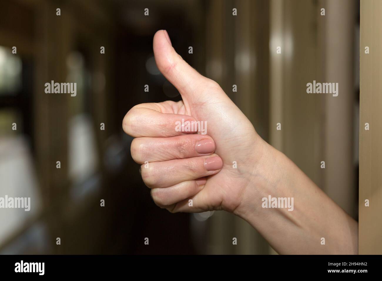 A woman's hand shows a class conductor of a railway train with a thumb ...