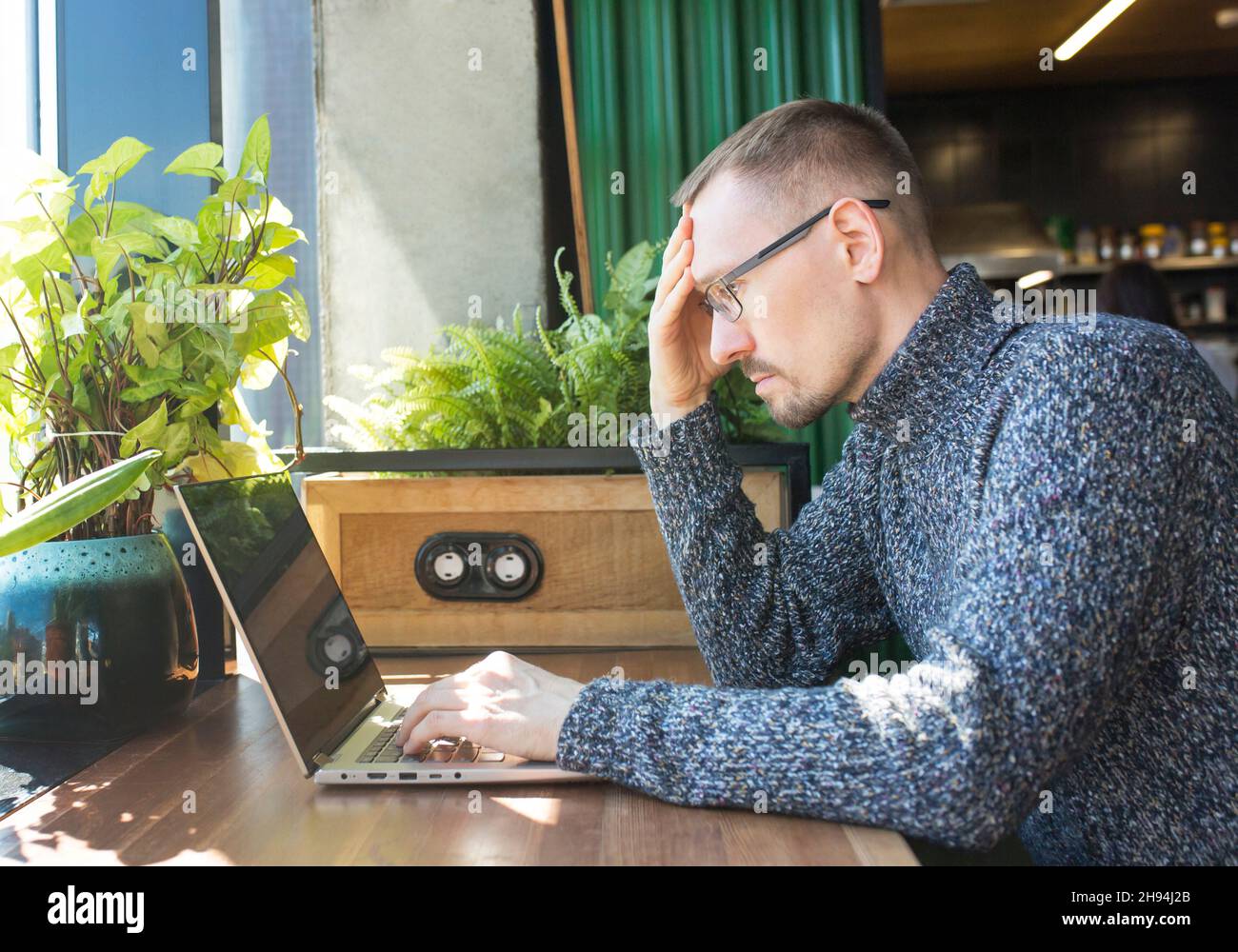 Tired businessman is trying to solve problem with work. A Man sits with ...