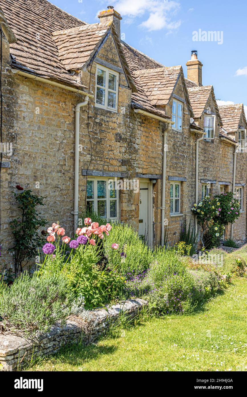 Traditional stone cottages in the Cotswold village of Withington ...