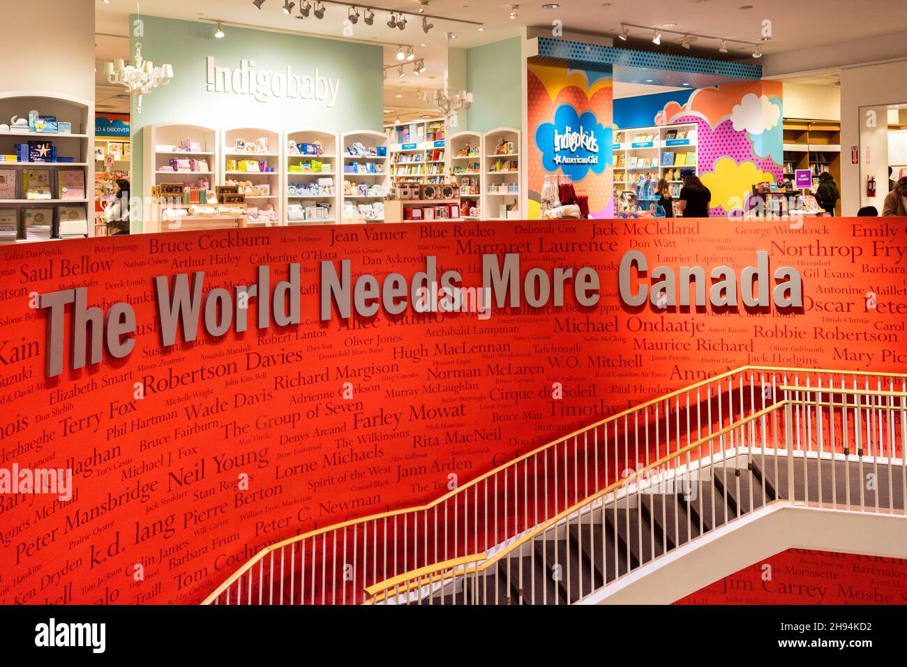 Inside an Indigo bookstore with a sign reading, 'The World Needs More ...