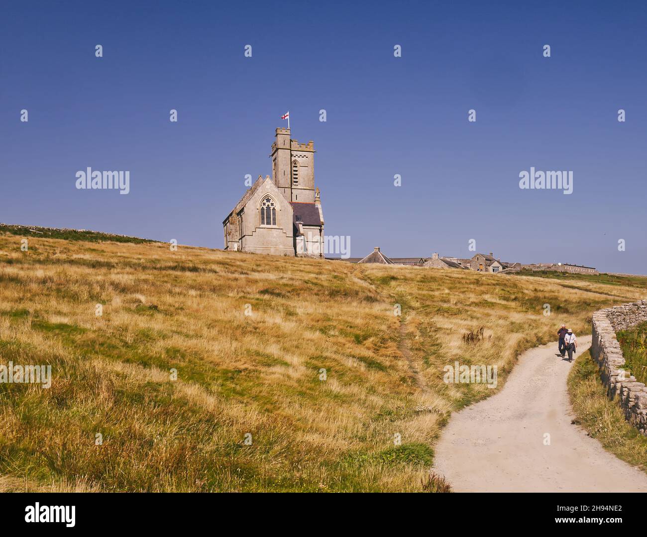 People walking along the road past St Helen's Church from the village ...